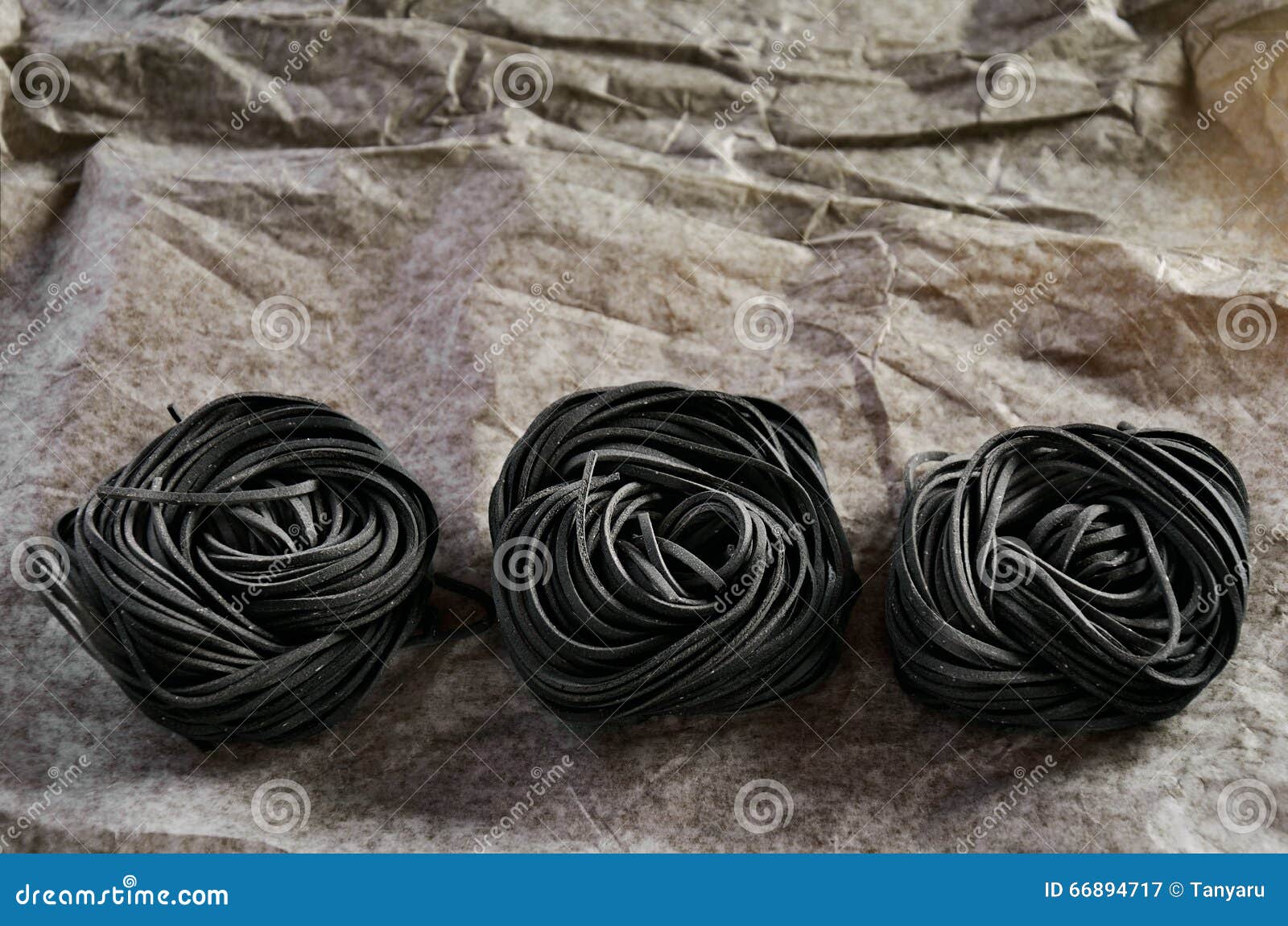 Three Servings of Pasta with Black Cuttlefish Ink on a Paper Background ...