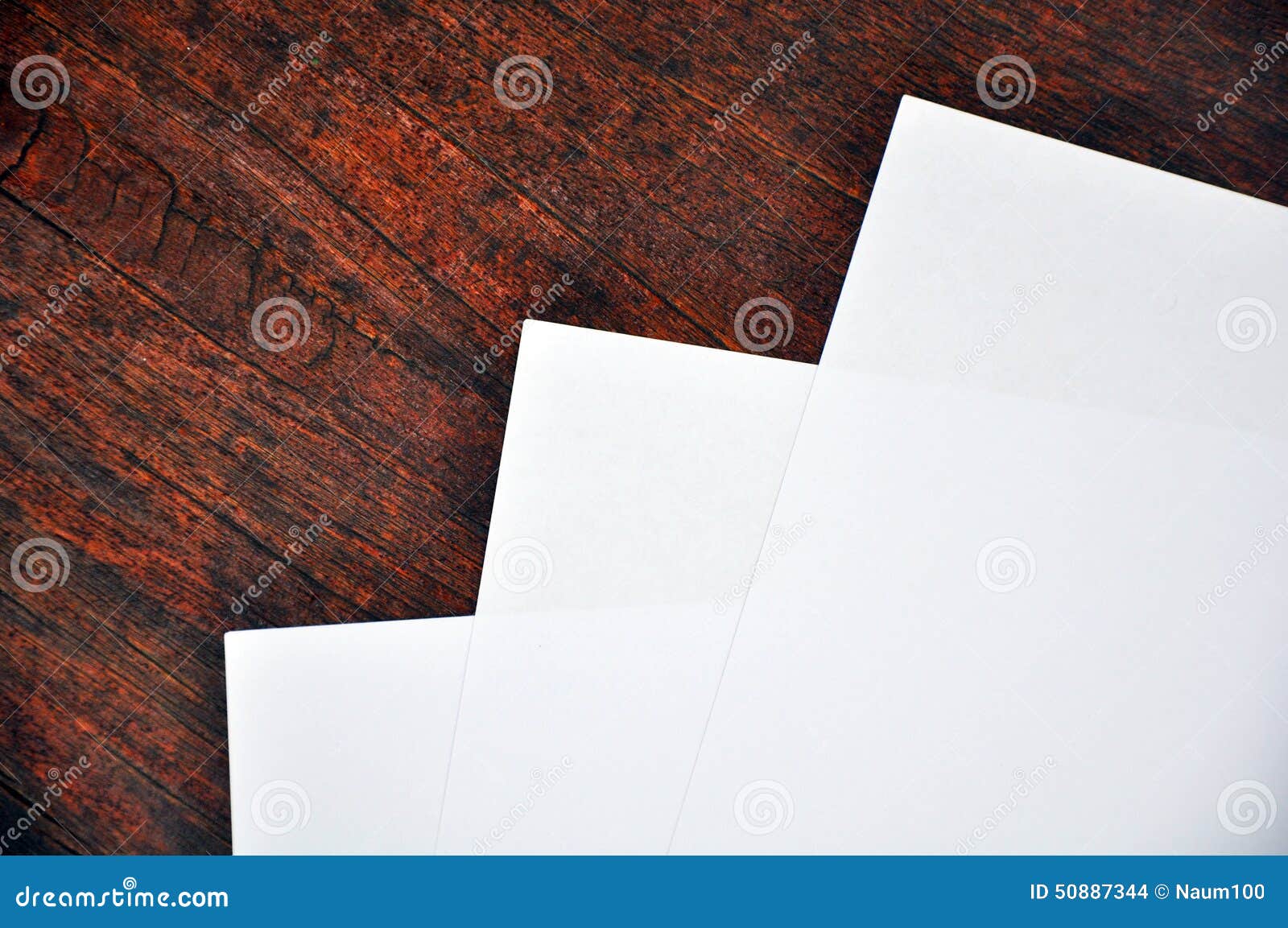 Three Sheets of White Paper Lying on a Wooden Surface Stock Photo ...