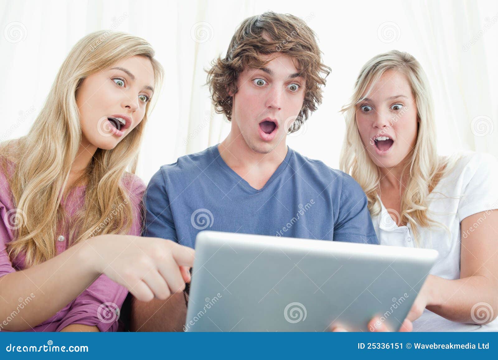 Three Shocked Friends Looking at the Screen of the Tablet Stock Image ...