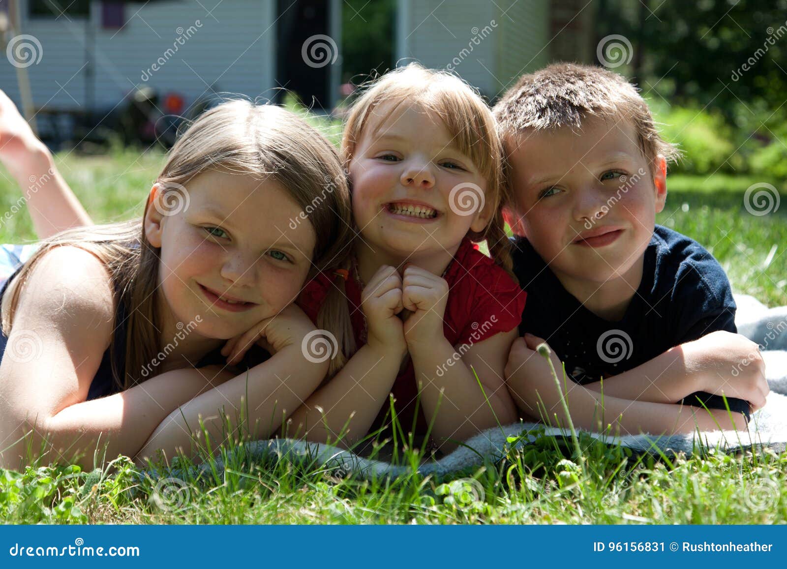 Three siblings in grass stock image. Image of cute, rest - 96156831