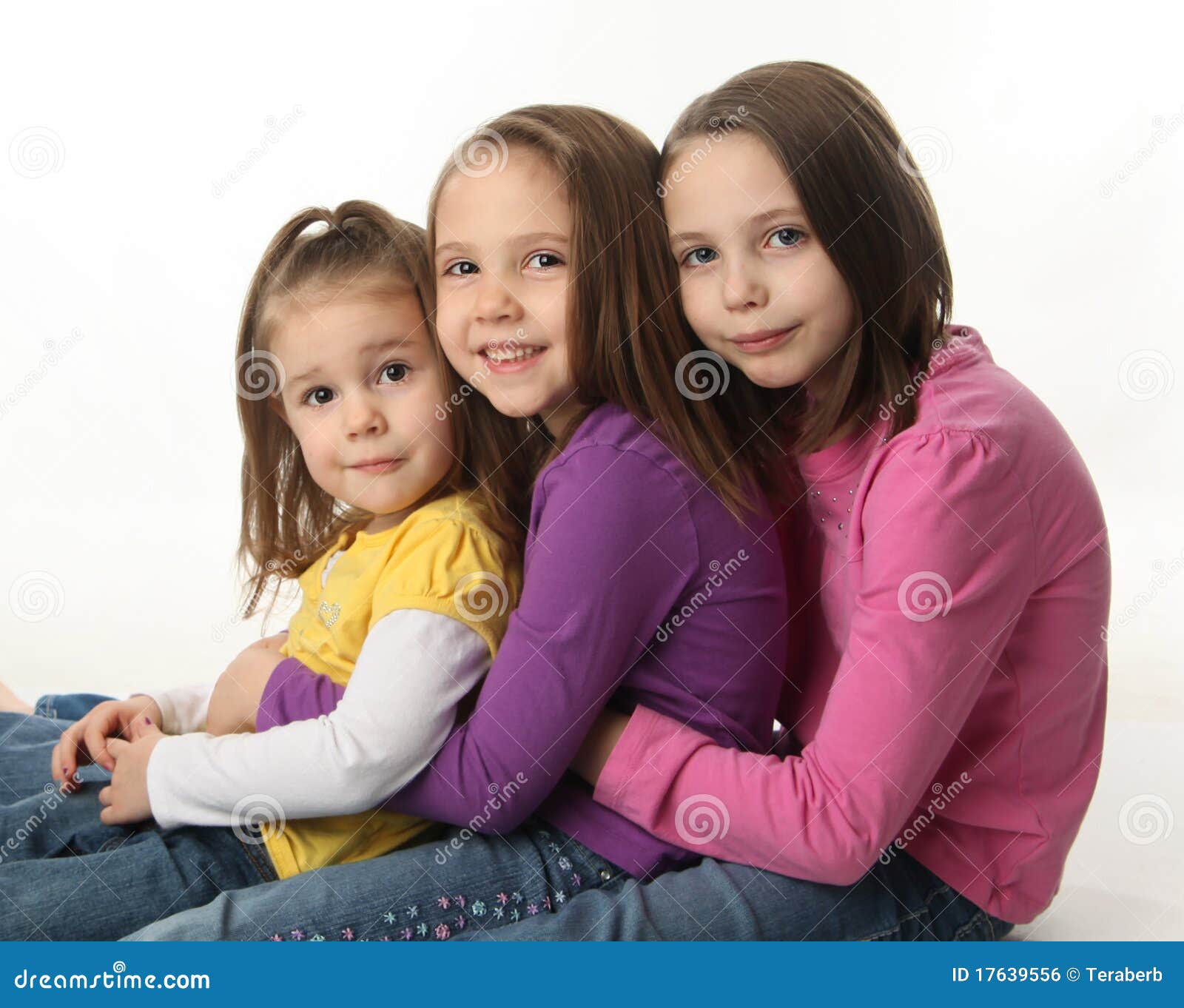 Three Sisters Sitting Down Hugging Each Other Stock Photo - Image of ...