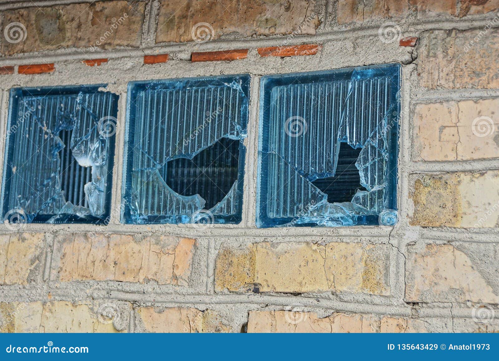Three Small Blue Square Ornamental Windows with Broken Glass on a Brick ...