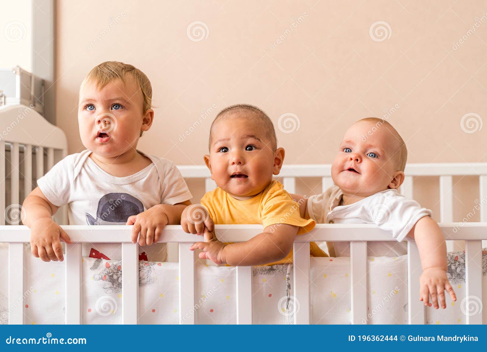 Three Small Funny Babies are Standing in the Crib Stock Photo - Image ...