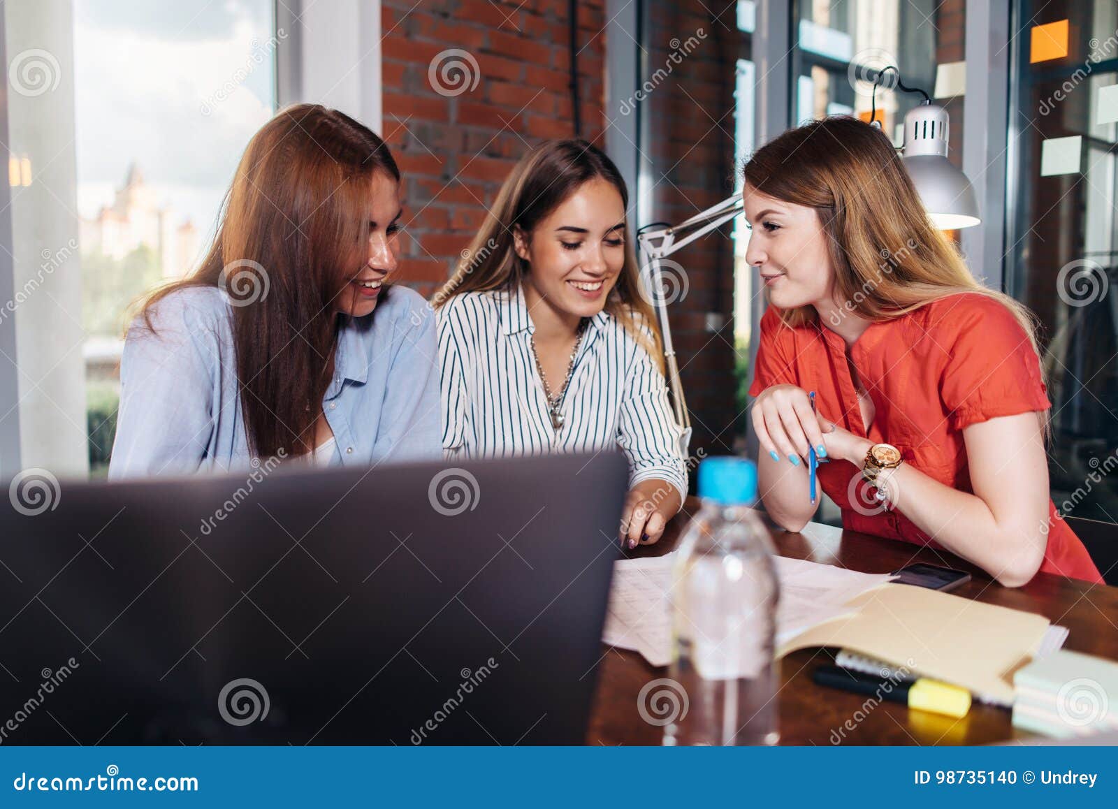 Three Smiling Female College Students Working on Project Together in ...