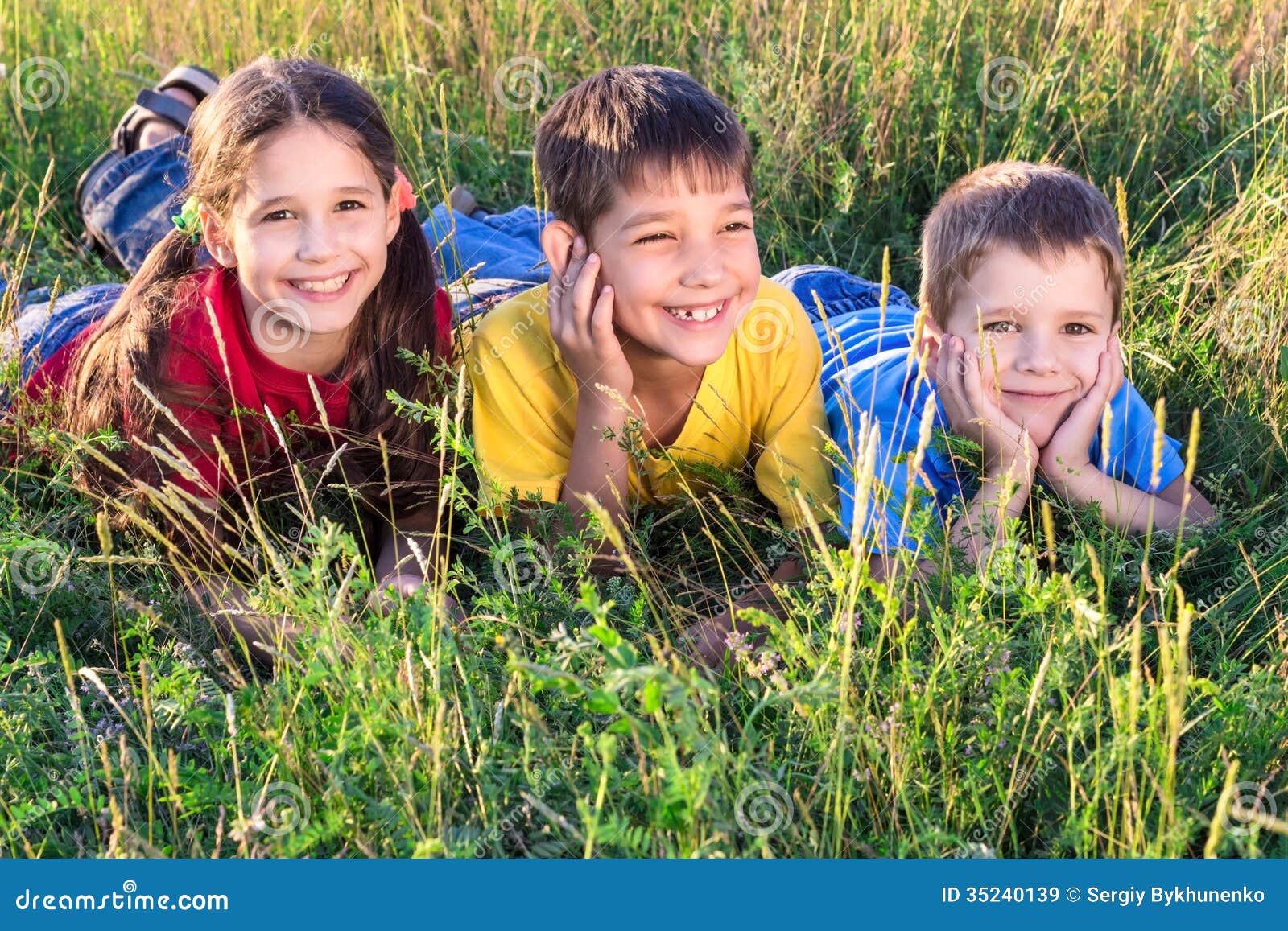 Three Smiling Kids on the Meadow Stock Image - Image of group ...