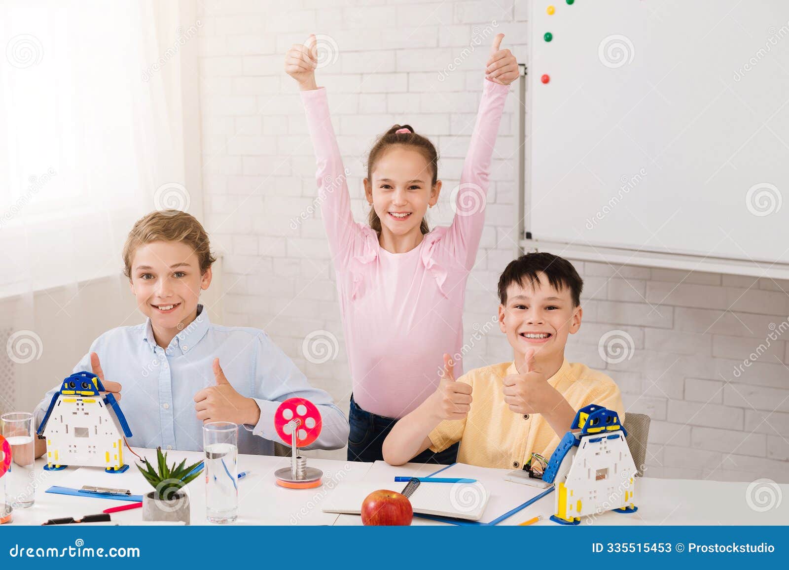 Three Smiling Students Giving Thumbs Up in a Classroom Setting Stock ...