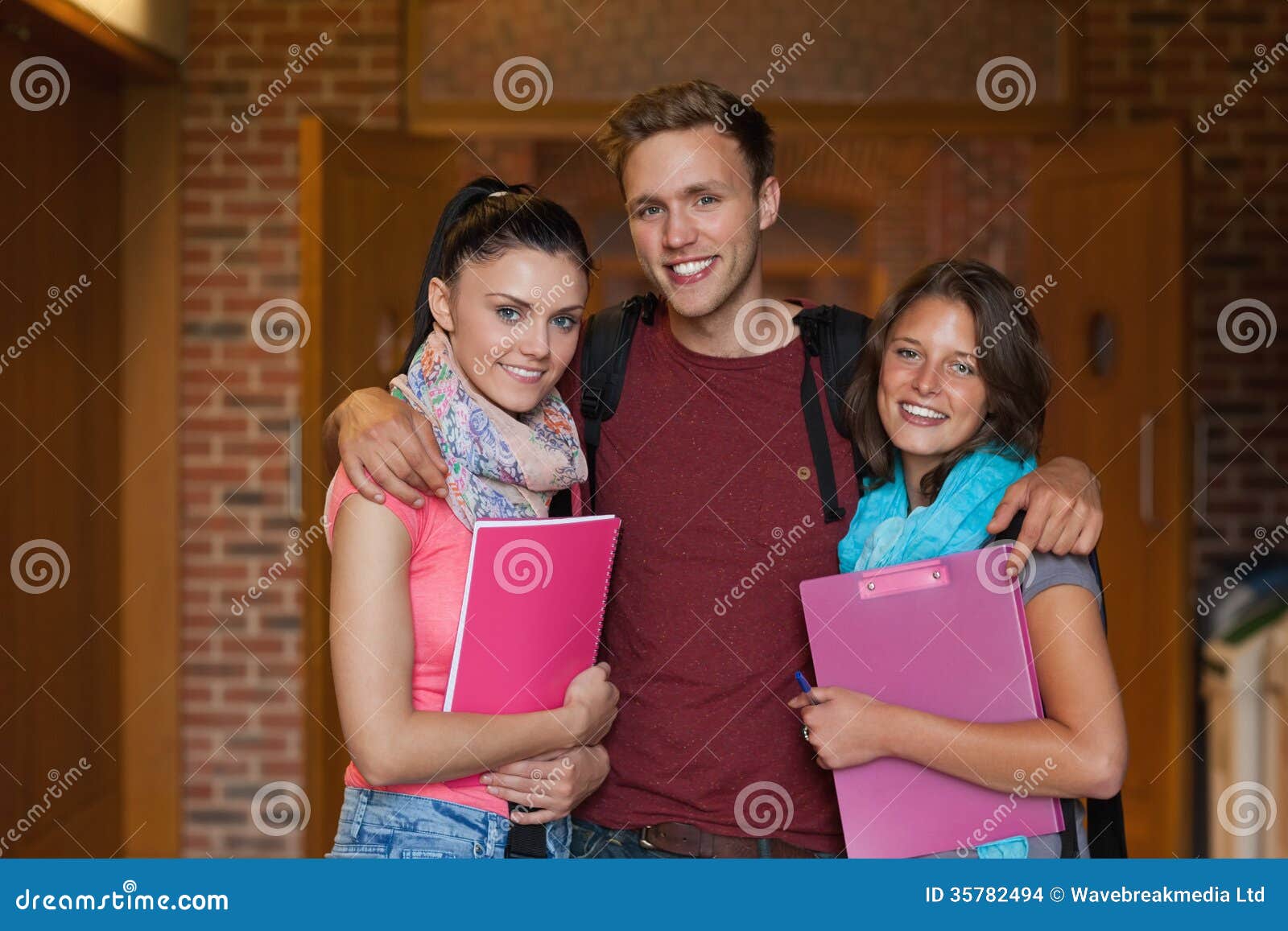 Three Smiling Students Posing in Hallway Stock Photo - Image of ...
