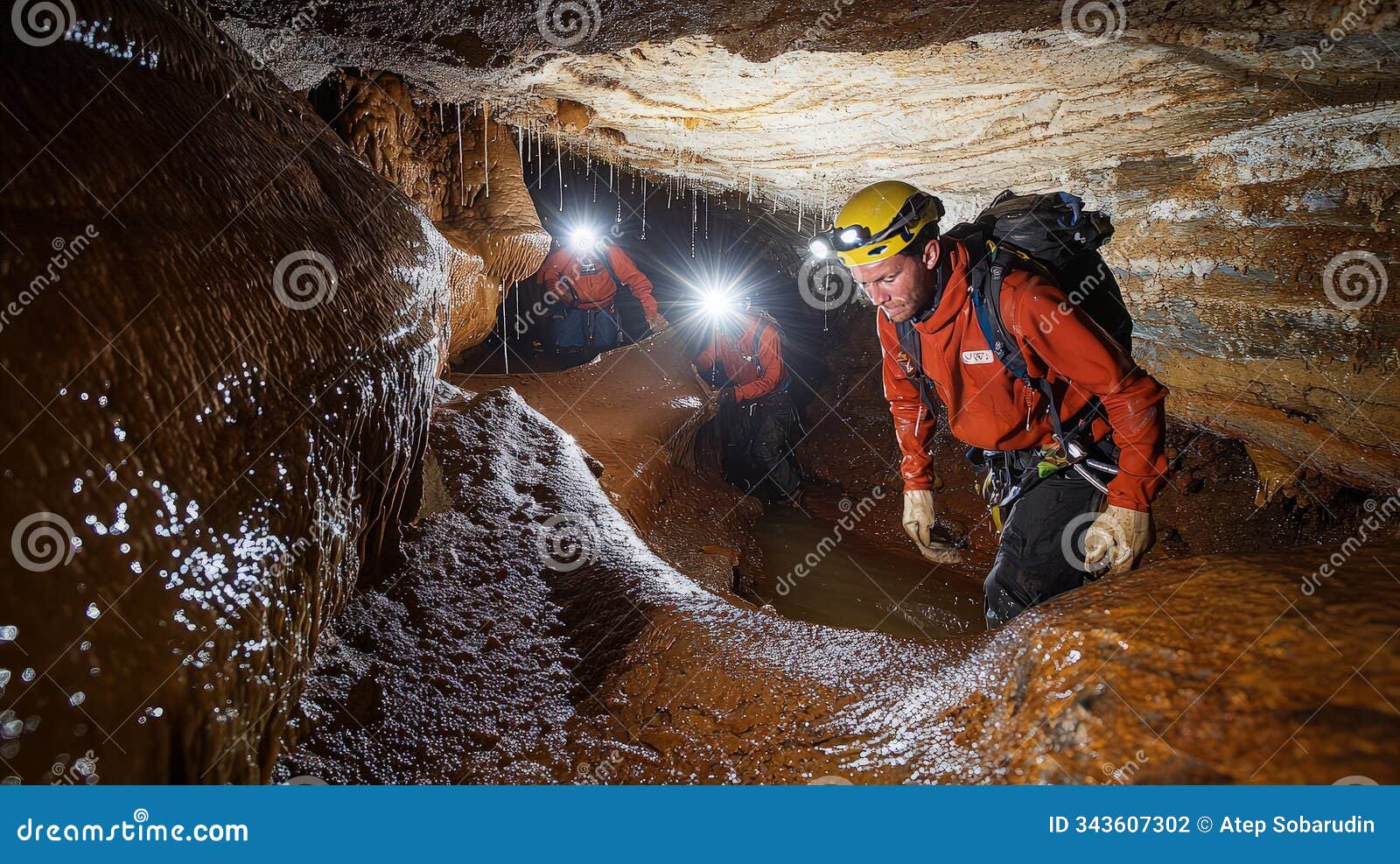 Three Spelunkers Explore a Dark Cave, Using Headlamps To Navigate the ...
