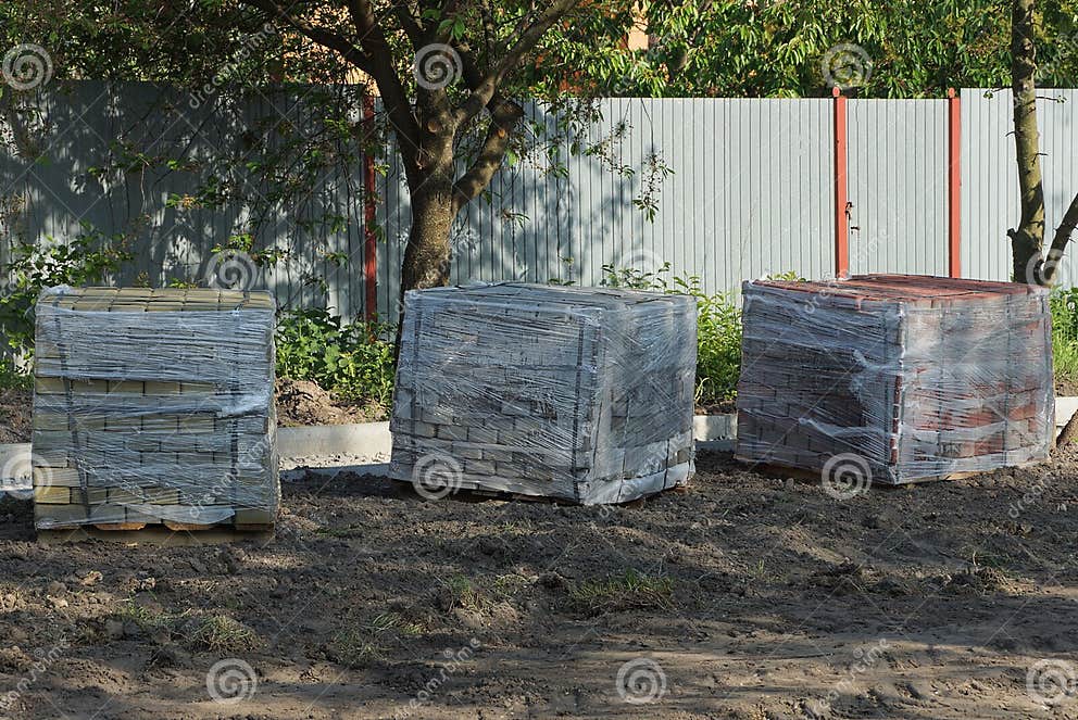 Three Square Boxes in Plastic Packaging with Paving Bricks Stock Image ...