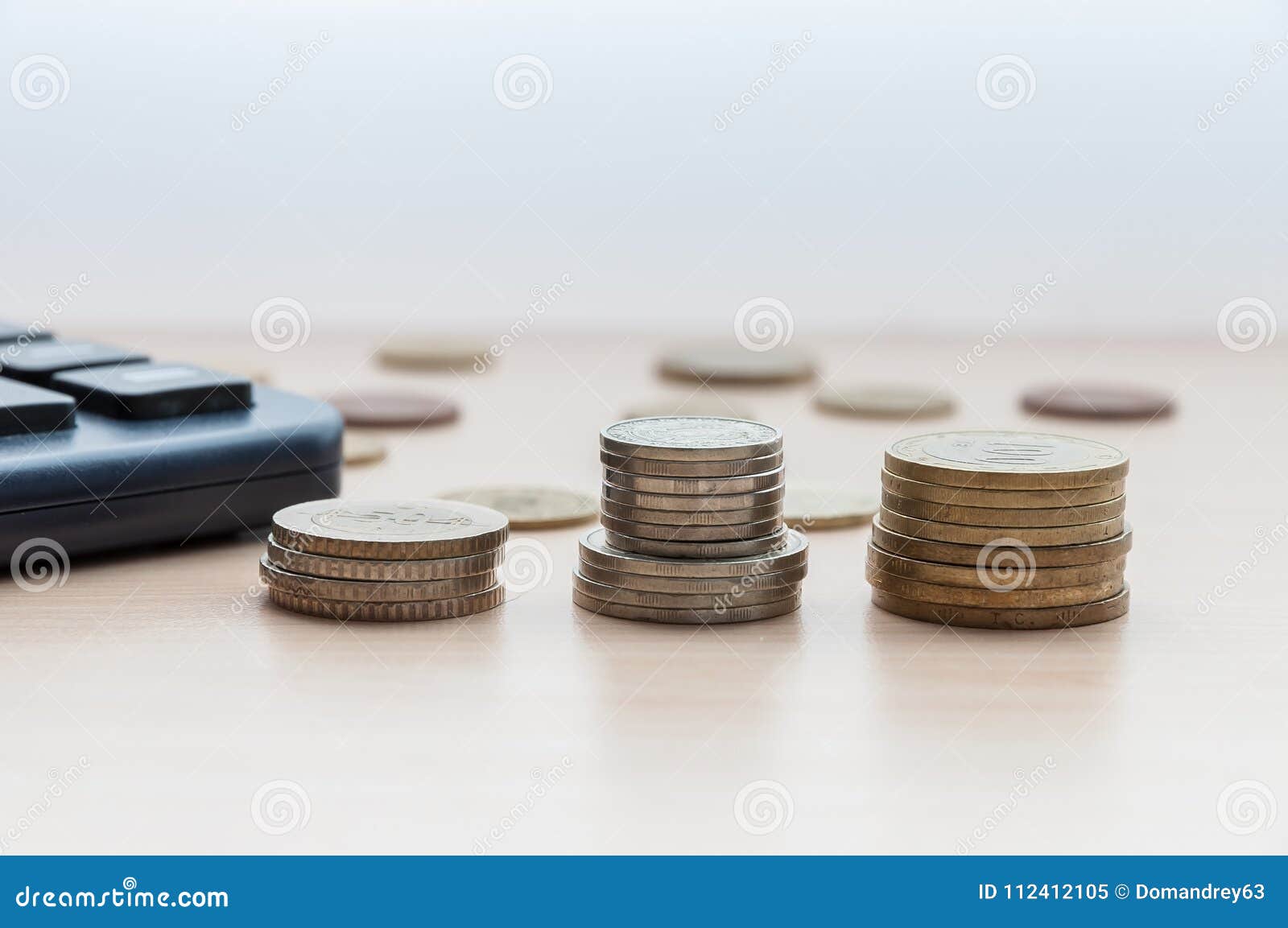 Three Stacks of Coins and a Calculator are on the Table Stock Image ...