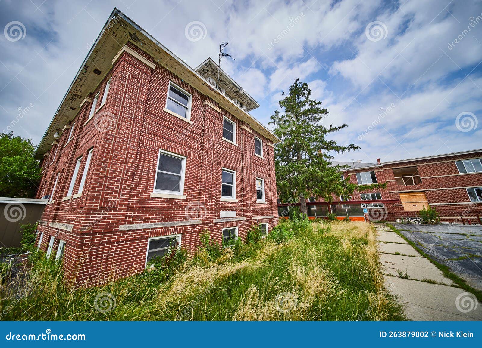 Three Story Abandoned Brick Buildings with Overgrown Fields Stock Photo ...