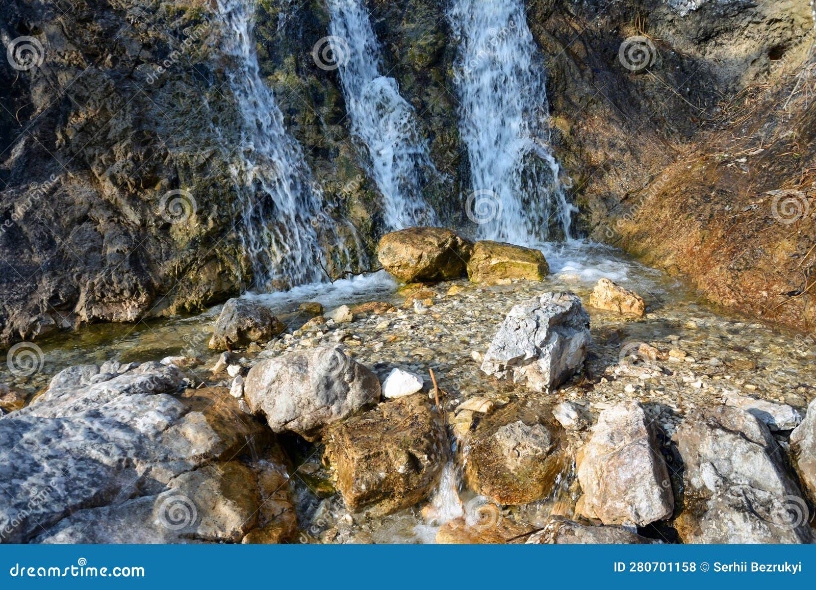 Three Streams of the Waterfall Flow Down the Rock Onto the Stones ...