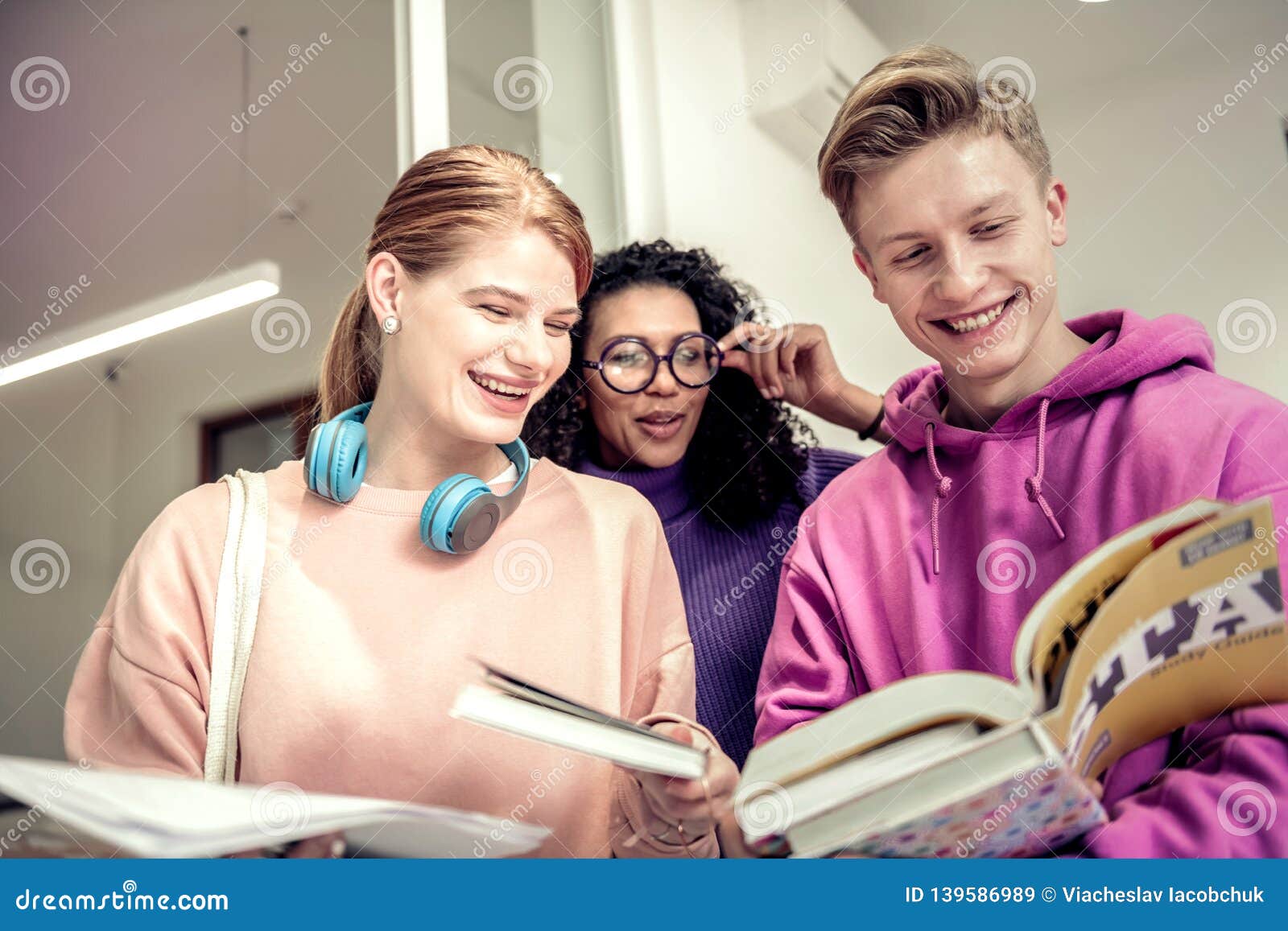 Three Students Feeling Cheerful Studying Together Near Classroom Stock ...