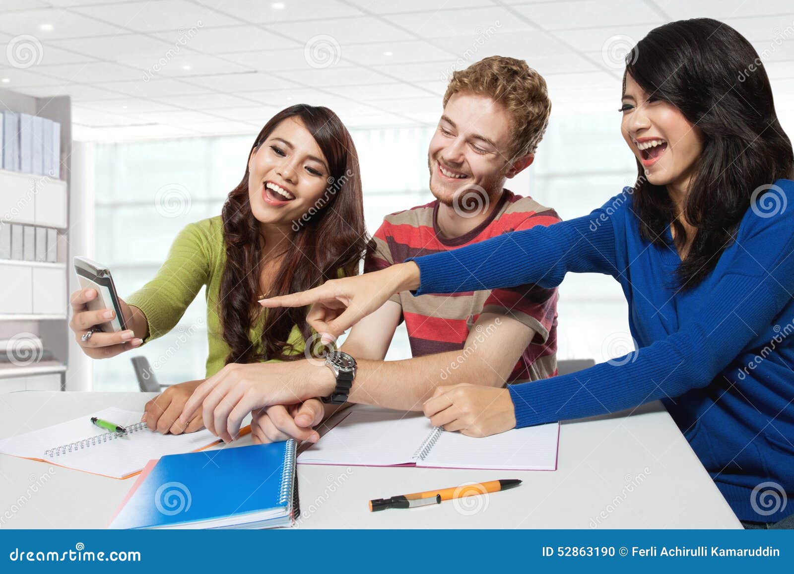 Three Students Laugh at Something on a Handphone Stock Photo - Image of ...