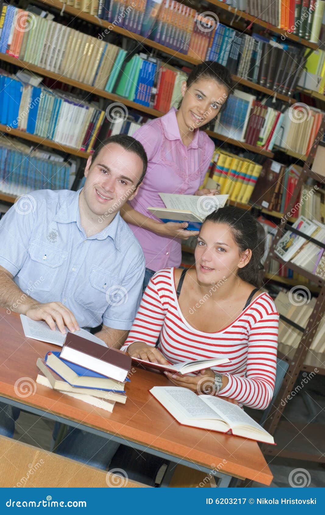 Three students in library stock image. Image of adult - 6203217