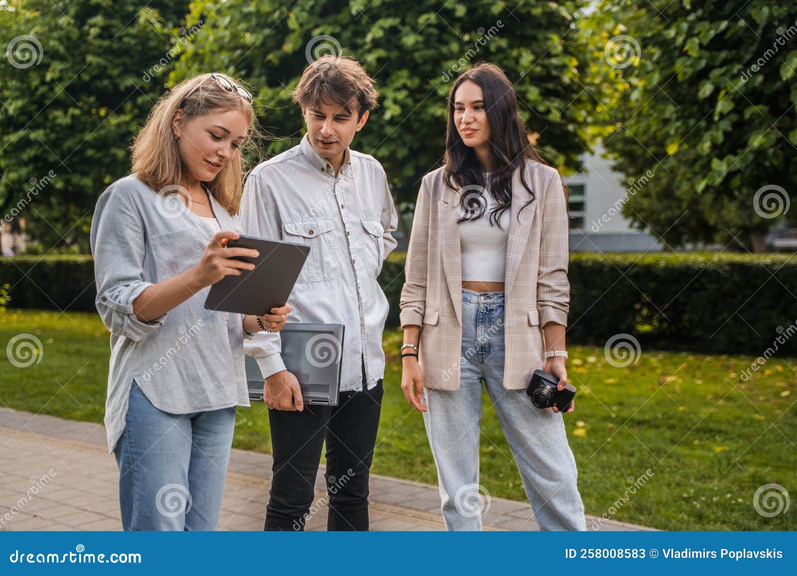 Three Students in Natural Park Browsing Tablet in Summertime Stock ...