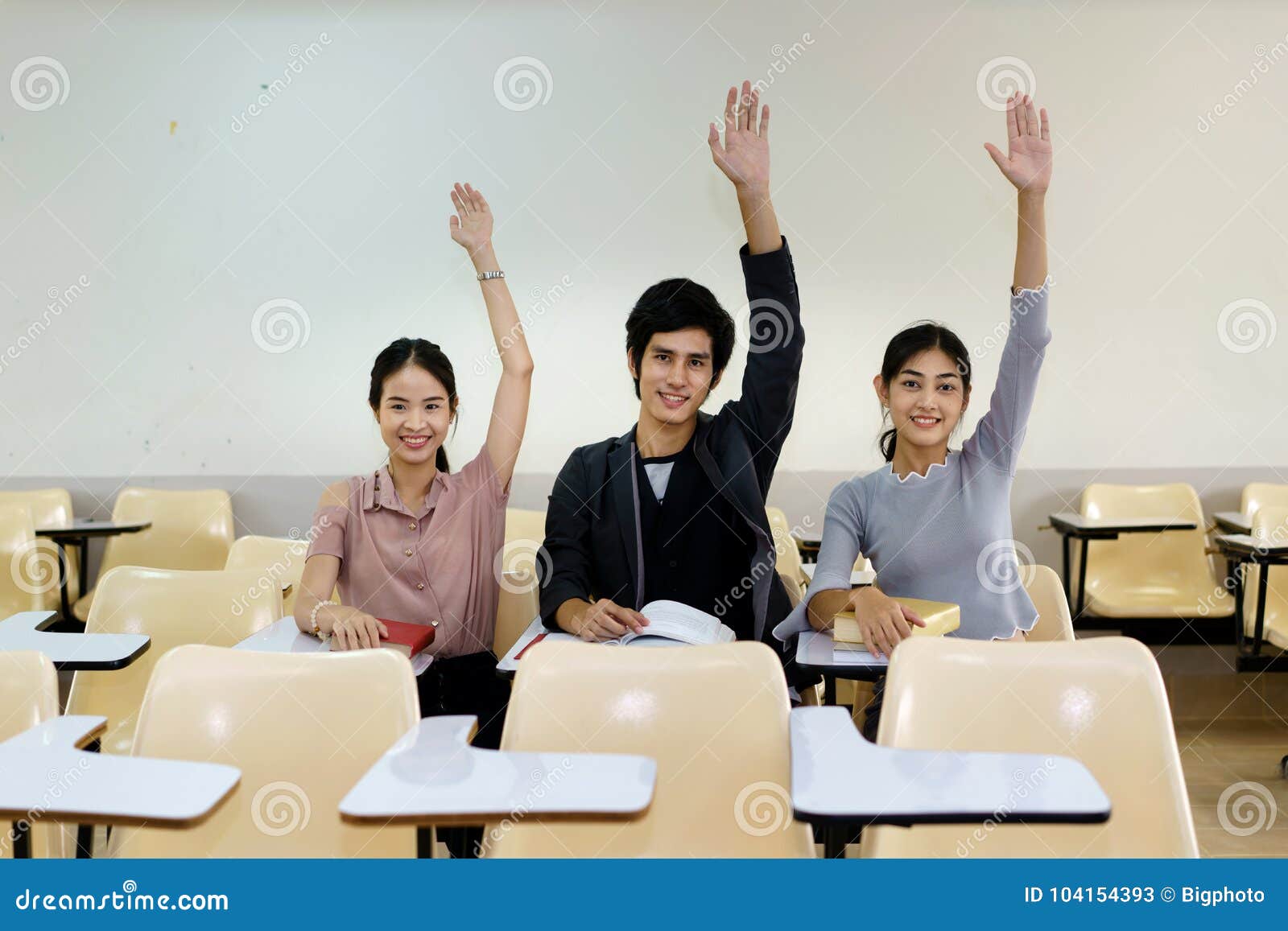 Three Students Raised Their Hands Together in the Classroom. Stock ...