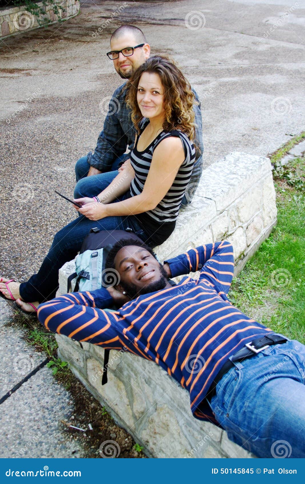 Three students relaxing stock image. Image of campus - 50145845