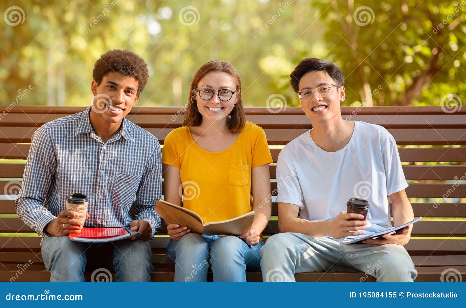 Three Students Sitting on Bench Relaxing Having Coffee Outdoor Stock ...