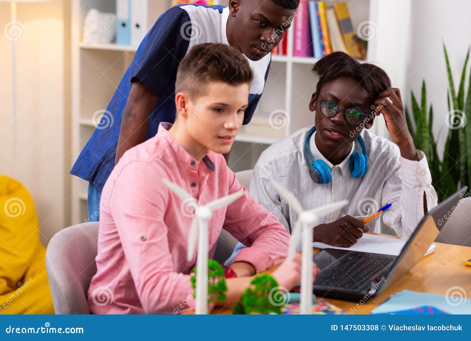 Three Students Sitting at the Laptop and Studying Ecology Together ...