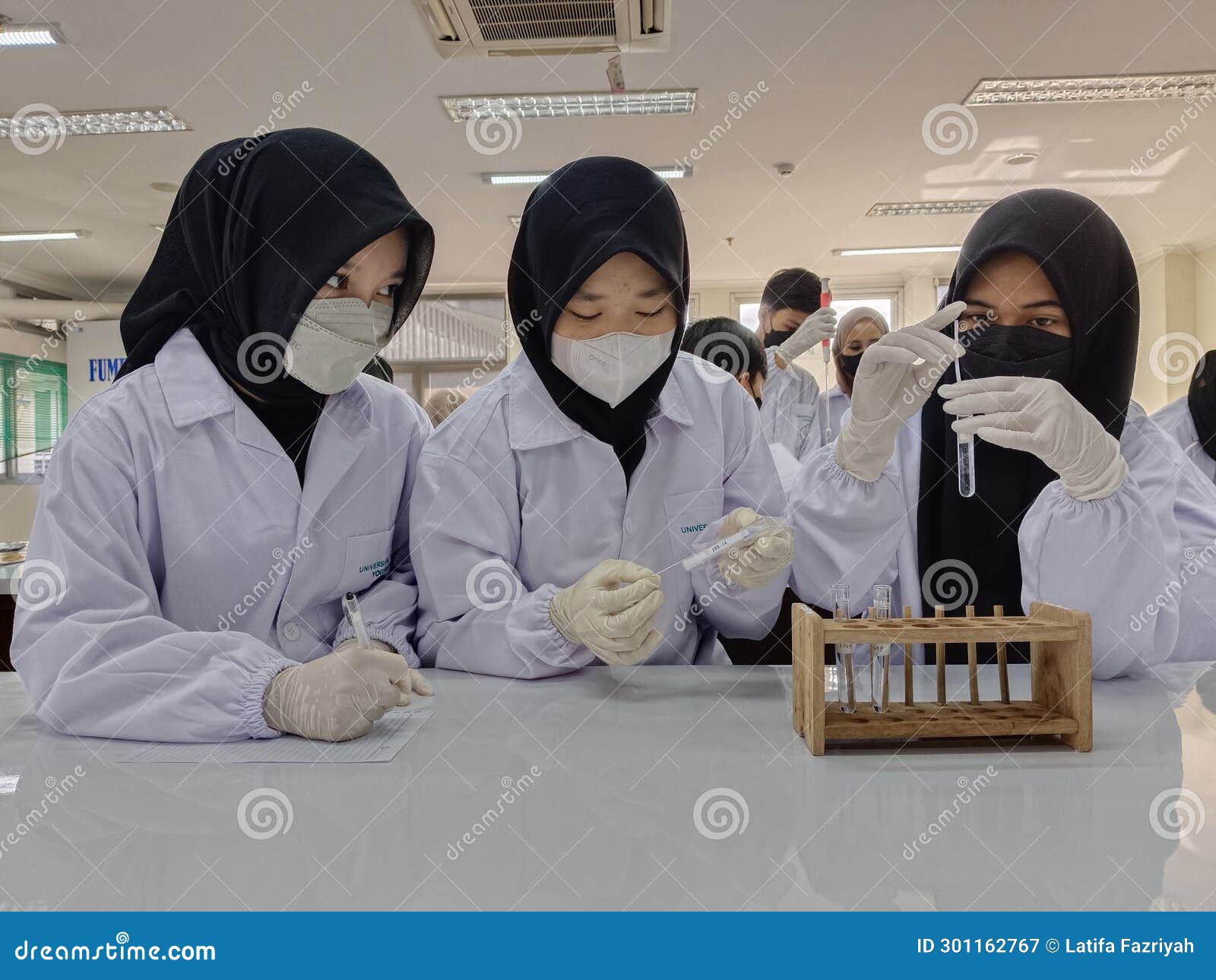 Three Students Wearing Hijab Doing Experiment in the Laboratorium ...
