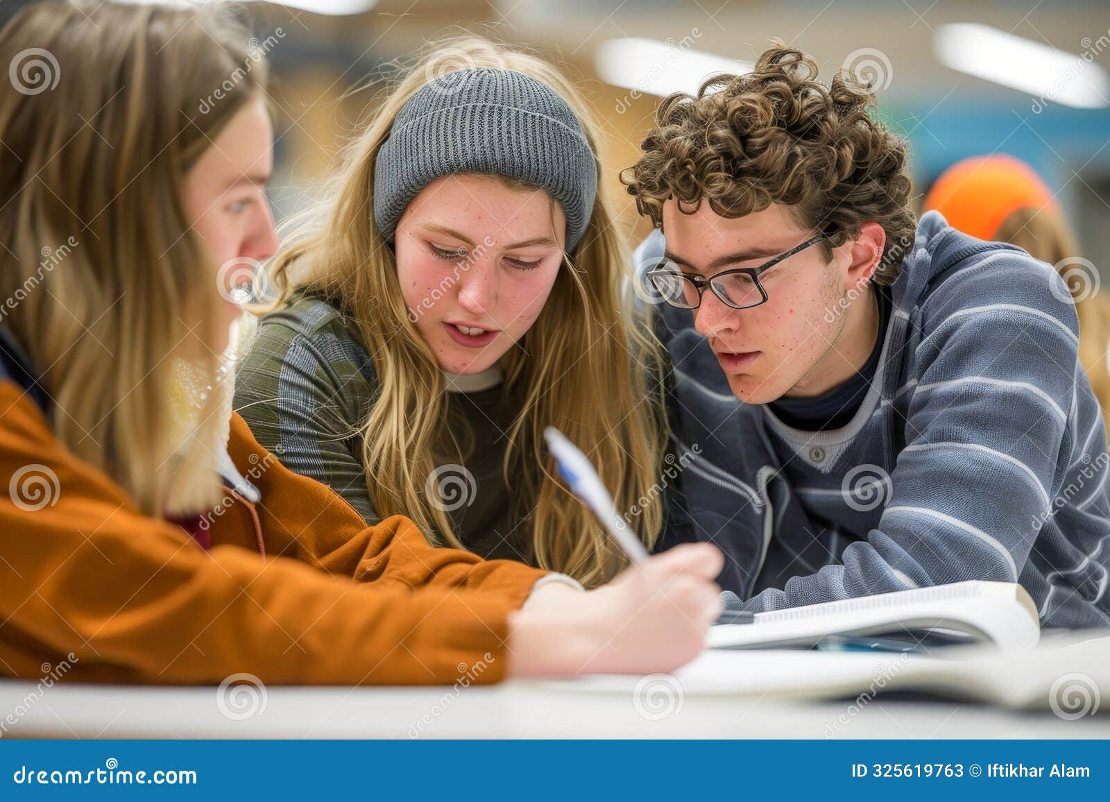Three Students Work Together on a Group Project, Focused Intently on ...