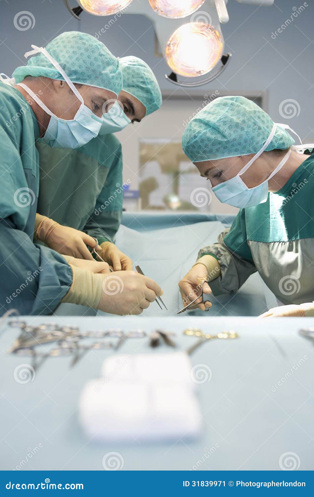 Three Surgeons At Work Operating In Surgical Theater Saving Patient And ...