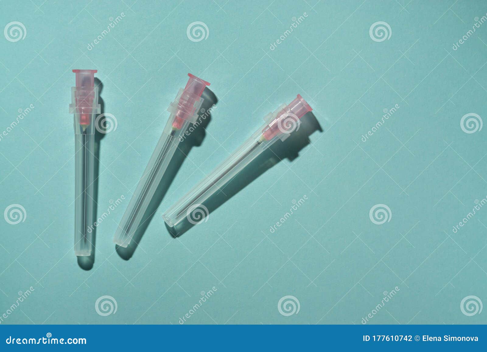 Three Syringe Needle in Protective Cap on Blue-green Background Stock ...