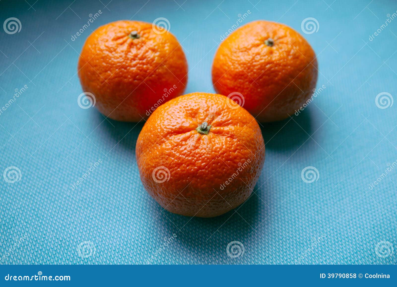Three Tangerines on Blue Background Stock Photo - Image of blue, group ...