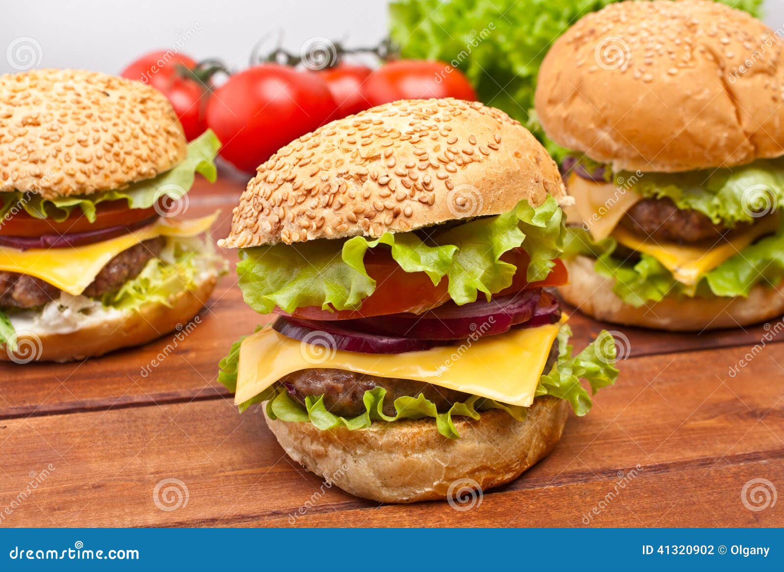 Three tasty cheeseburgers stock photo. Image of onion - 41320902