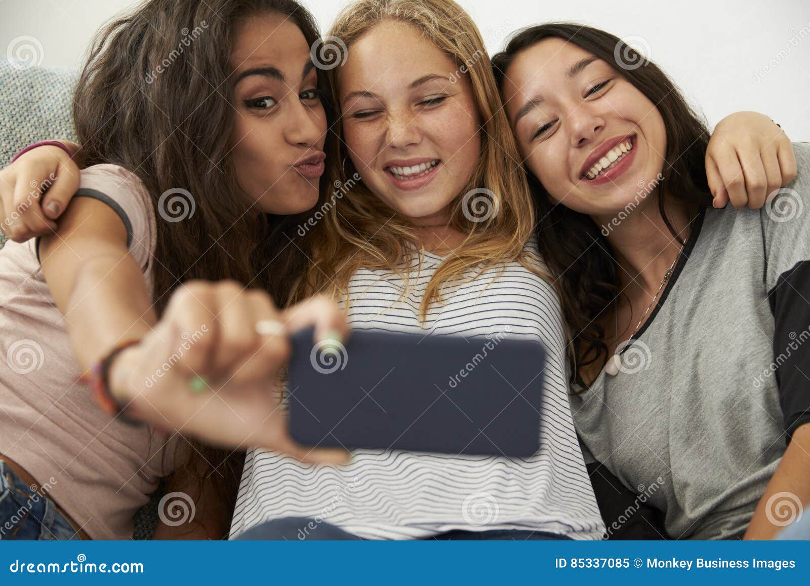 Three Teenage Girls Taking Selfie At Home Focus On Girls Stock Image