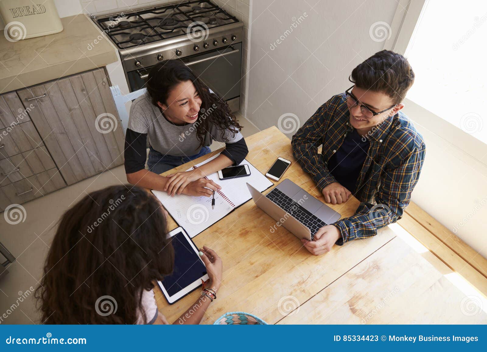Three Teens Study in Kitchen Using Computers, Elevated View Stock Image ...