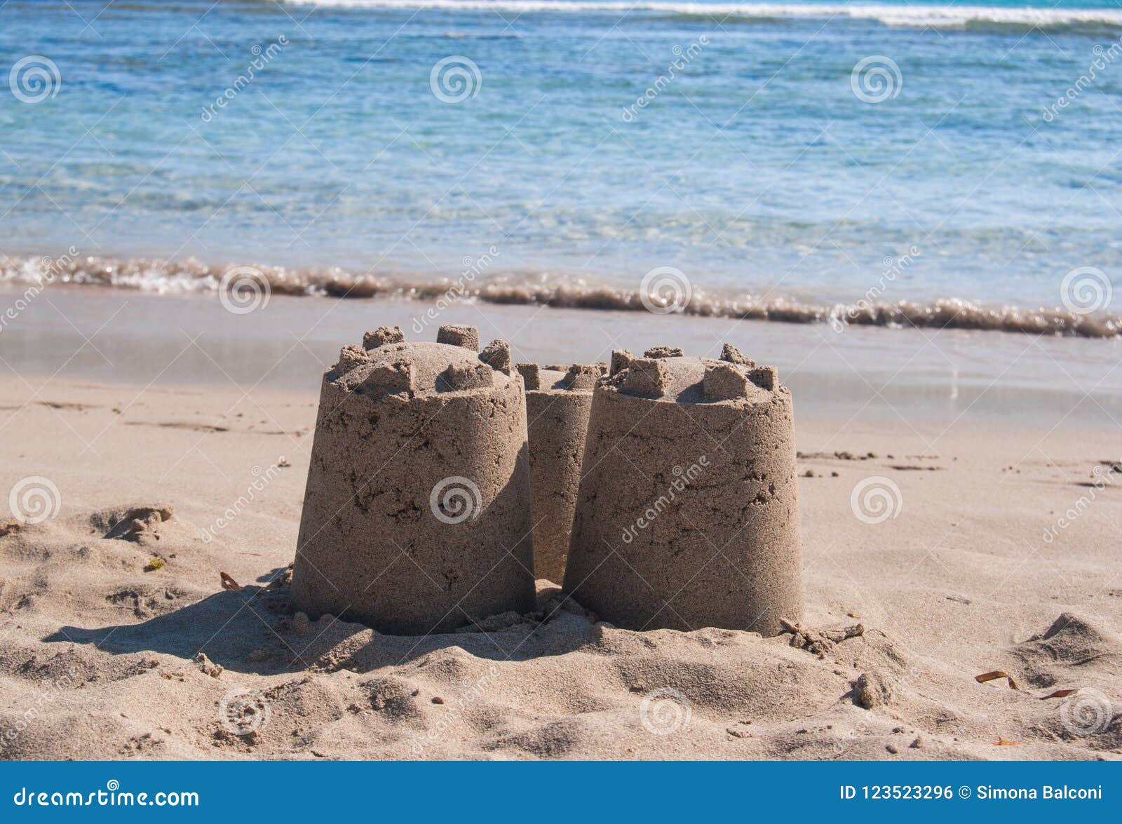 Three Towers of Sandy Castle on the Beach Stock Photo - Image of ...