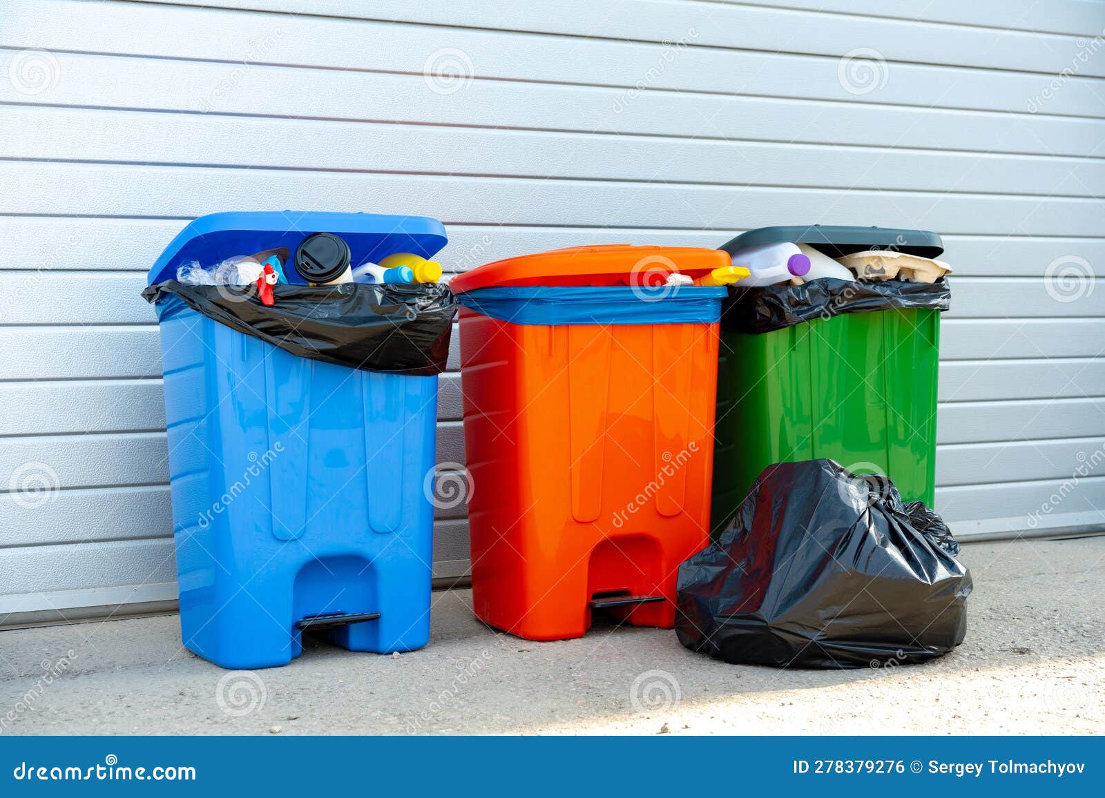 Three Trash Containers Full of Garbage Near the Building Stock Photo ...