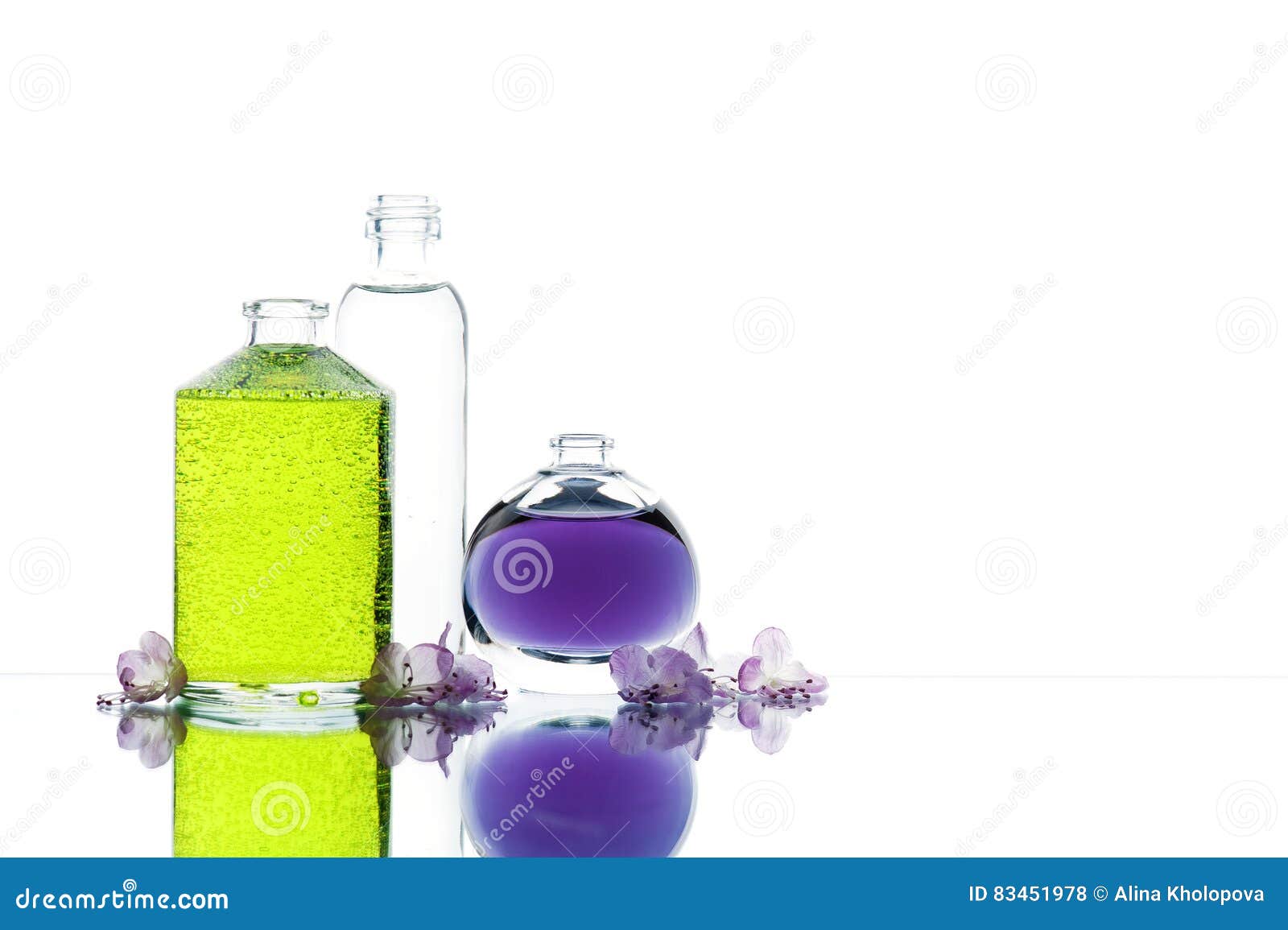Three Various Bottles with Color Liquid and Flowers Stock Photo - Image ...