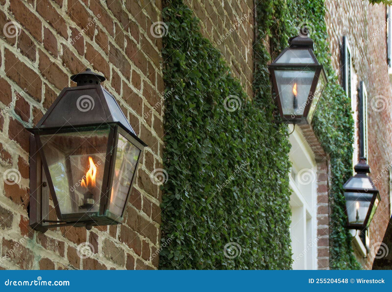 Three Vintage Lamps Hanging on an Old Stone Wall with Ivy Stock Photo ...