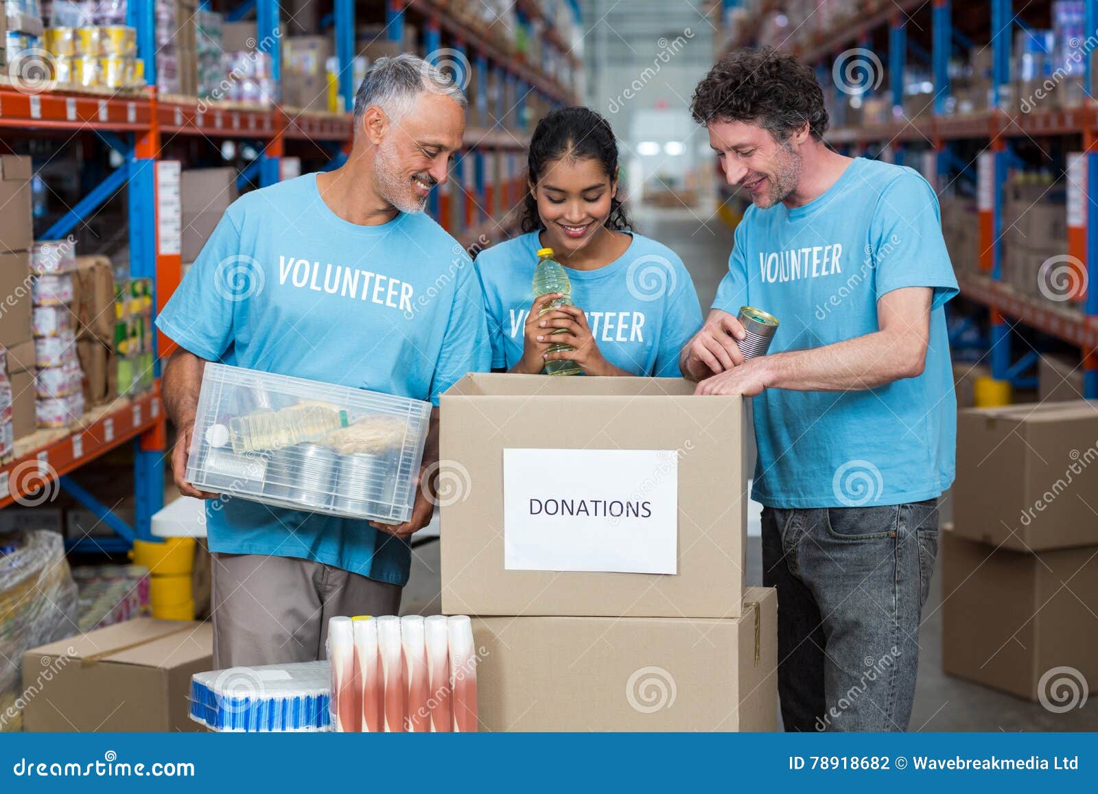 Three Volunteers Packing Eatables in Cardboard Box Stock Photo - Image ...