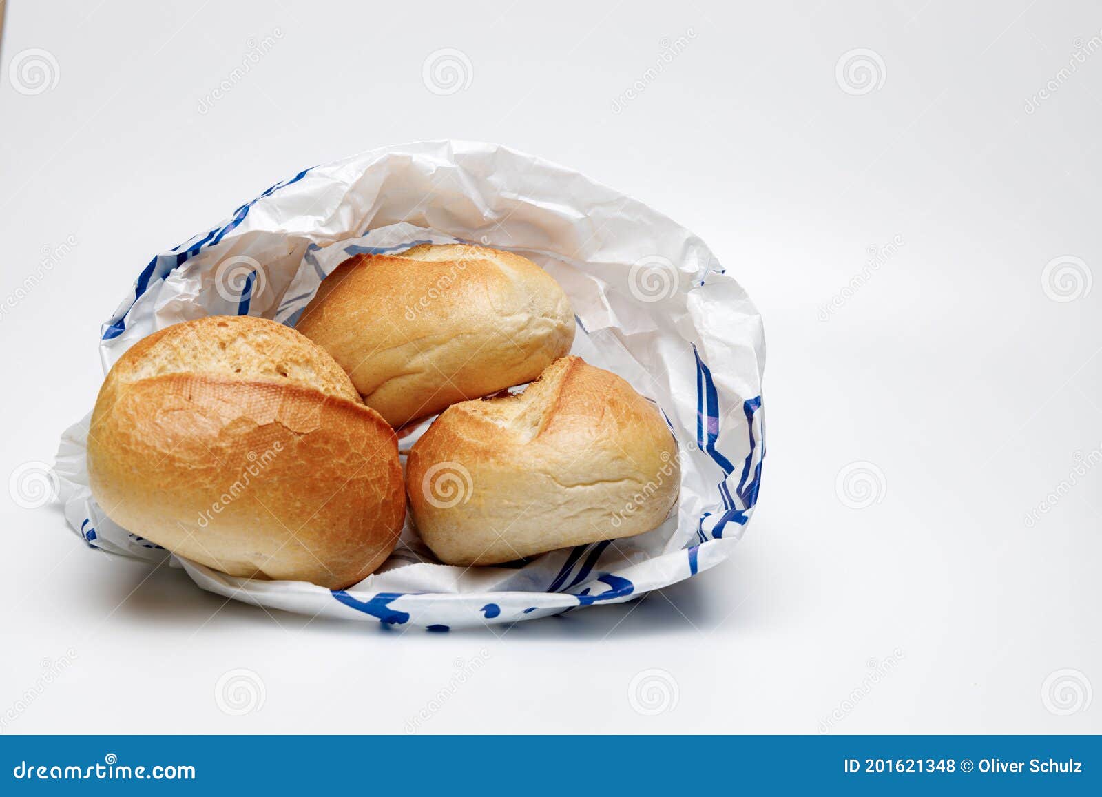 Three Wheat Buns in a Blue and White Paper Bag on a Uniform White ...
