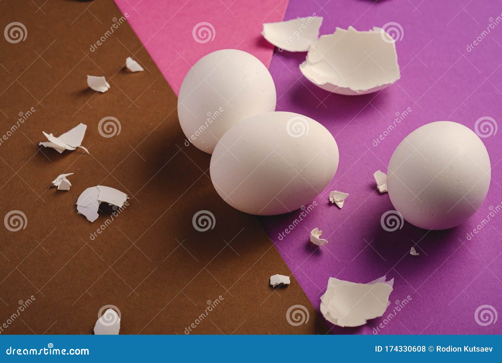 Three White Eggs with Eggshell Pieces on Purple, Pink and Brown Colors ...