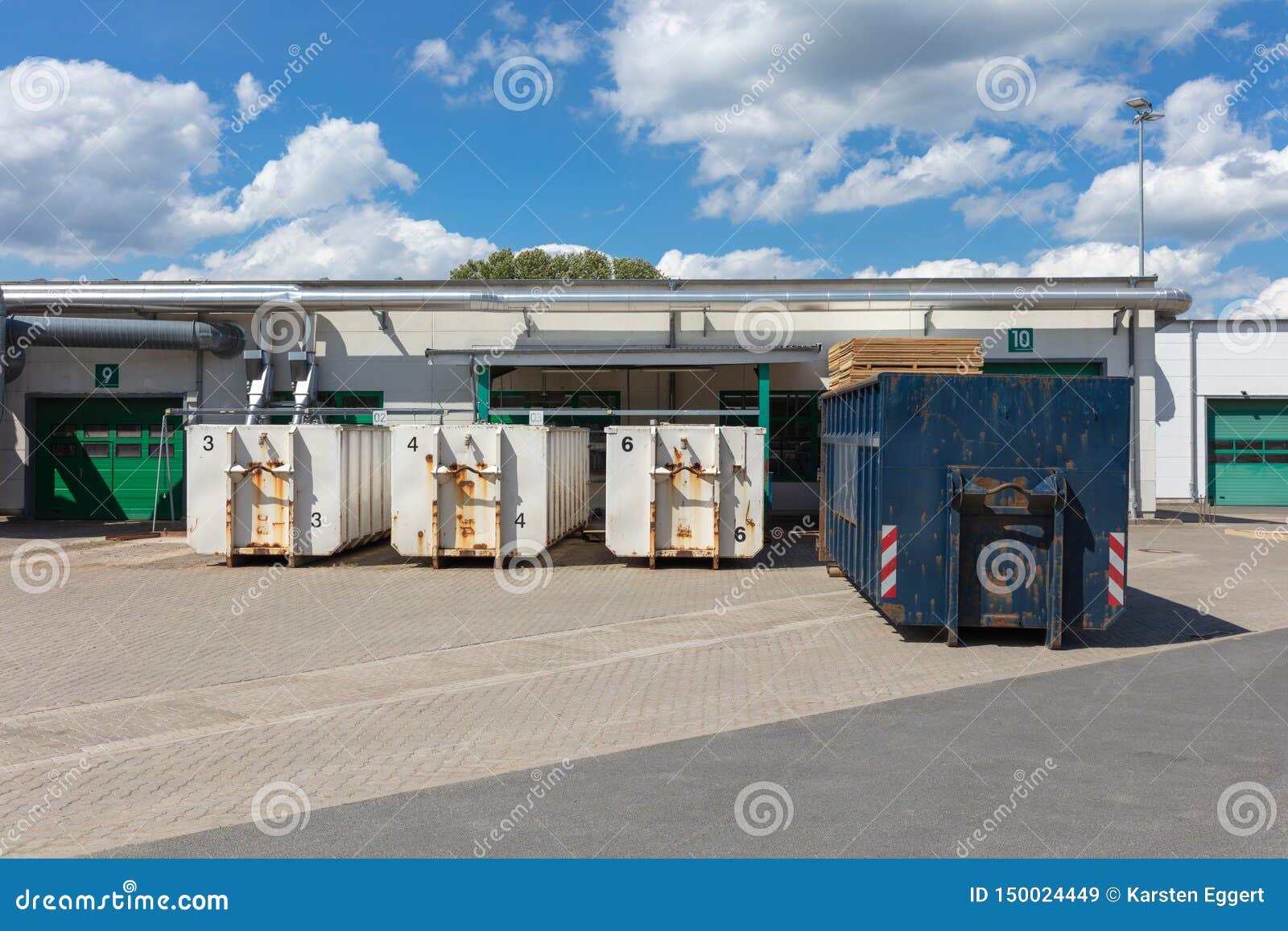 Three White Garbage Containers are Standing on a Factory Site and There ...