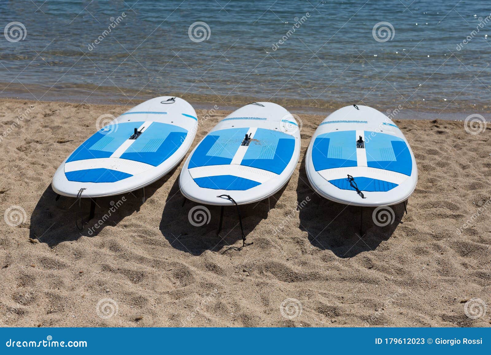Three White Surfboards Resting on the Shoreline on the Beach Stock ...