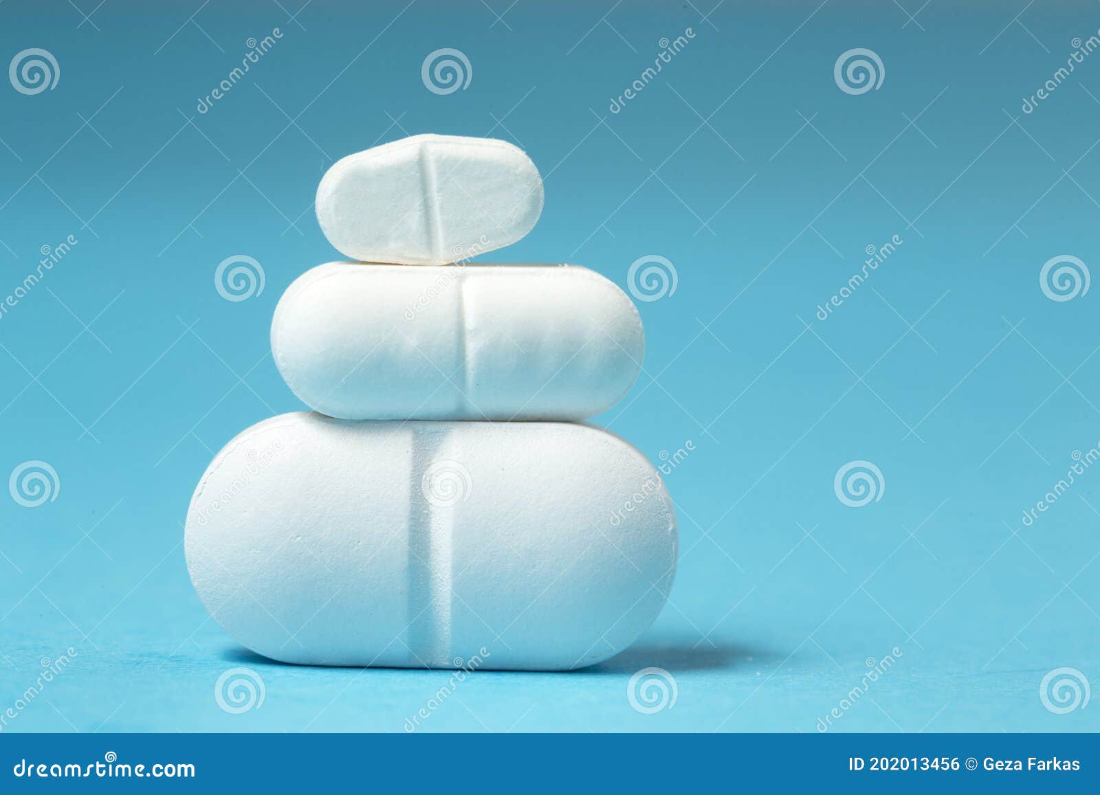 Three White Tablets of Different Sizes on Blue , Dosage Stock Photo ...