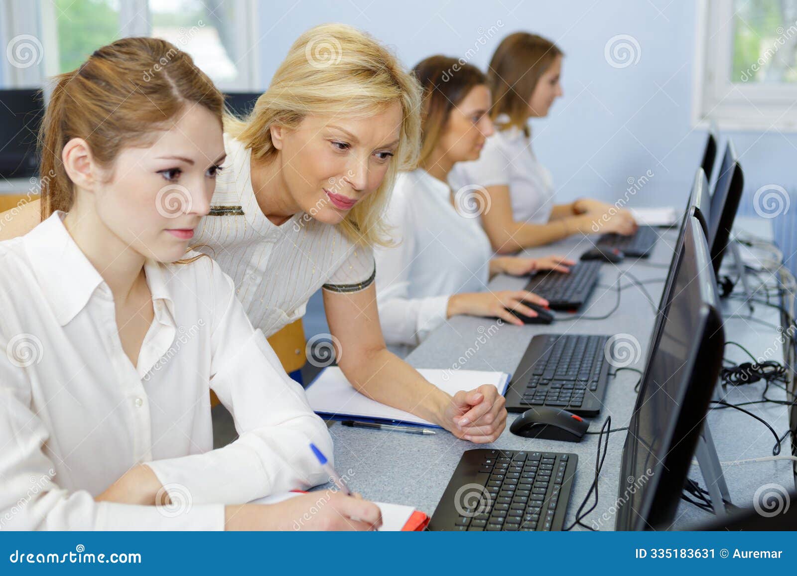 Three women in classroom stock image. Image of sitting - 335183631