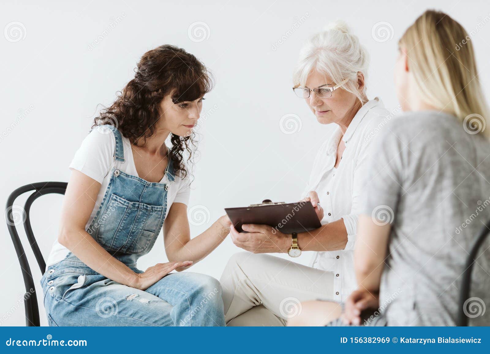 Three women discussing stock image. Image of overalls - 156382969