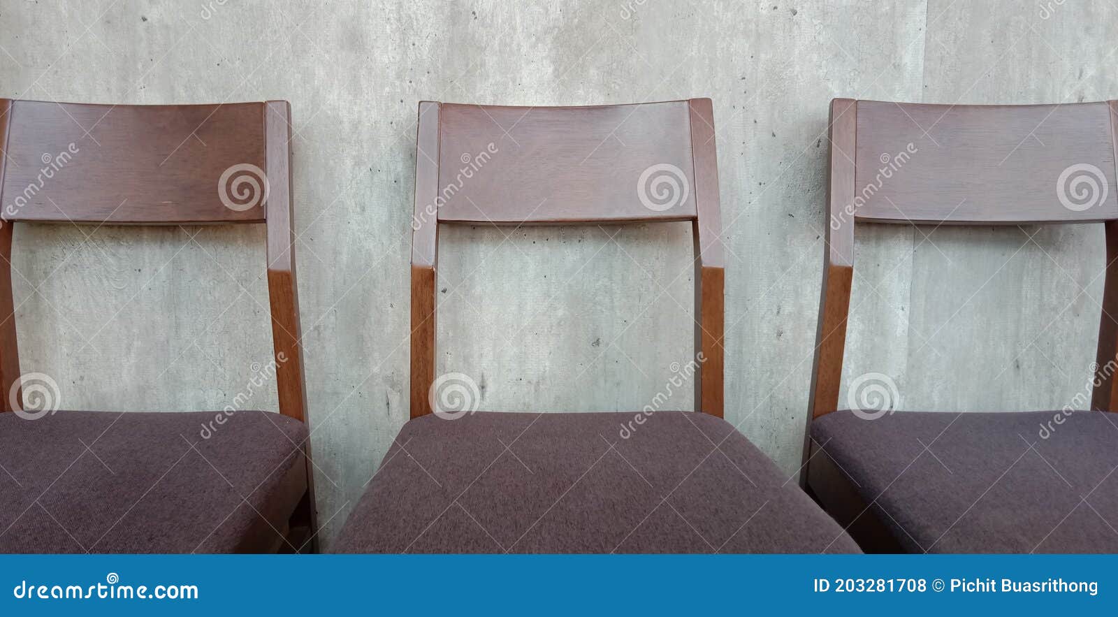 Three Wooden Chairs are Attached To the Cement Wall. Stock Photo ...