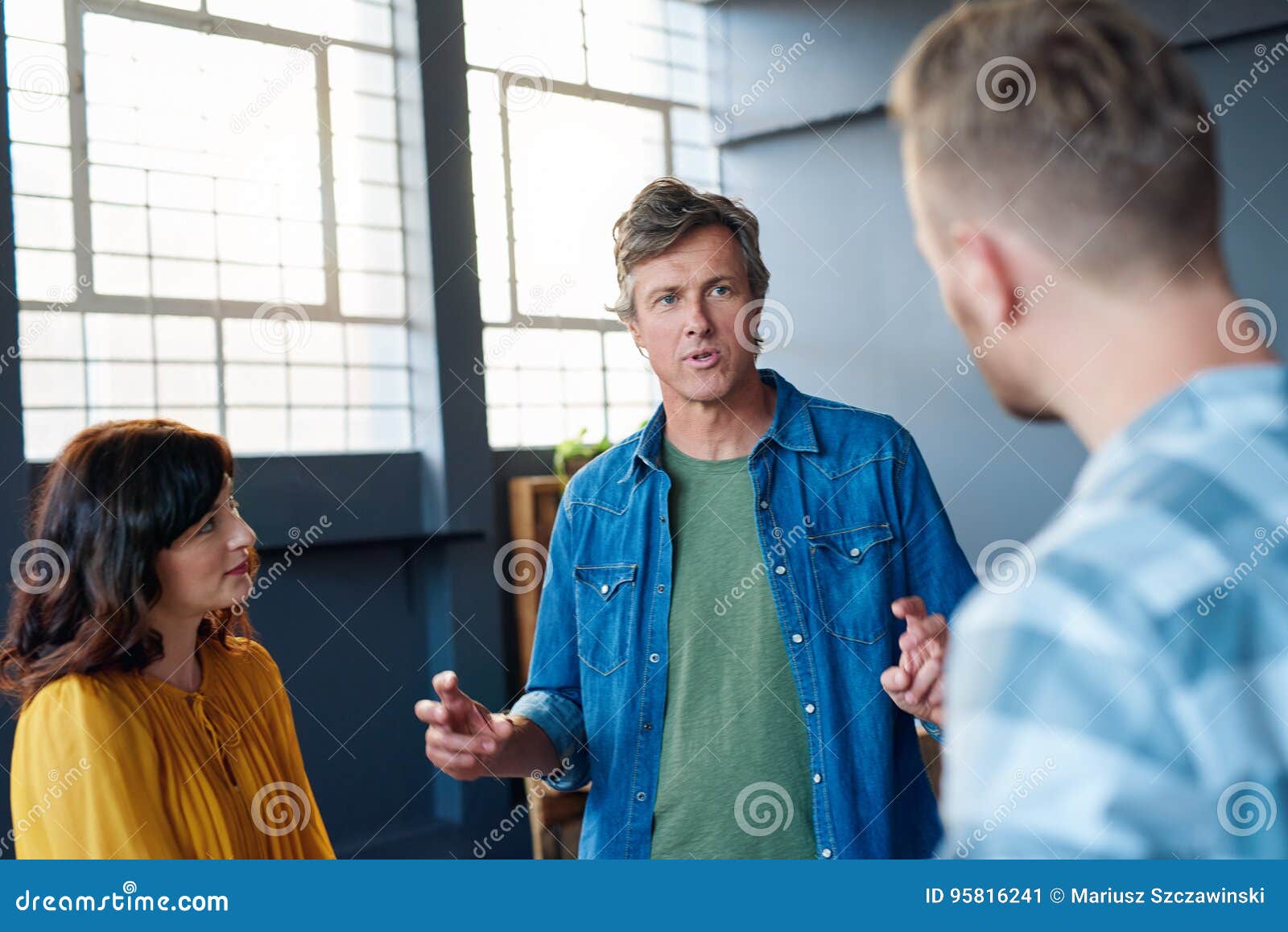 Three Work Colleagues Having a Discussion Together in an Office Stock ...