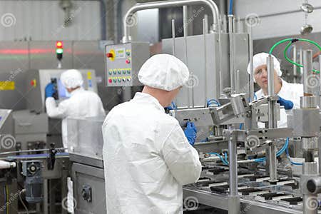 Three Workers in Uniforms at Production Line in Plant Stock Image ...