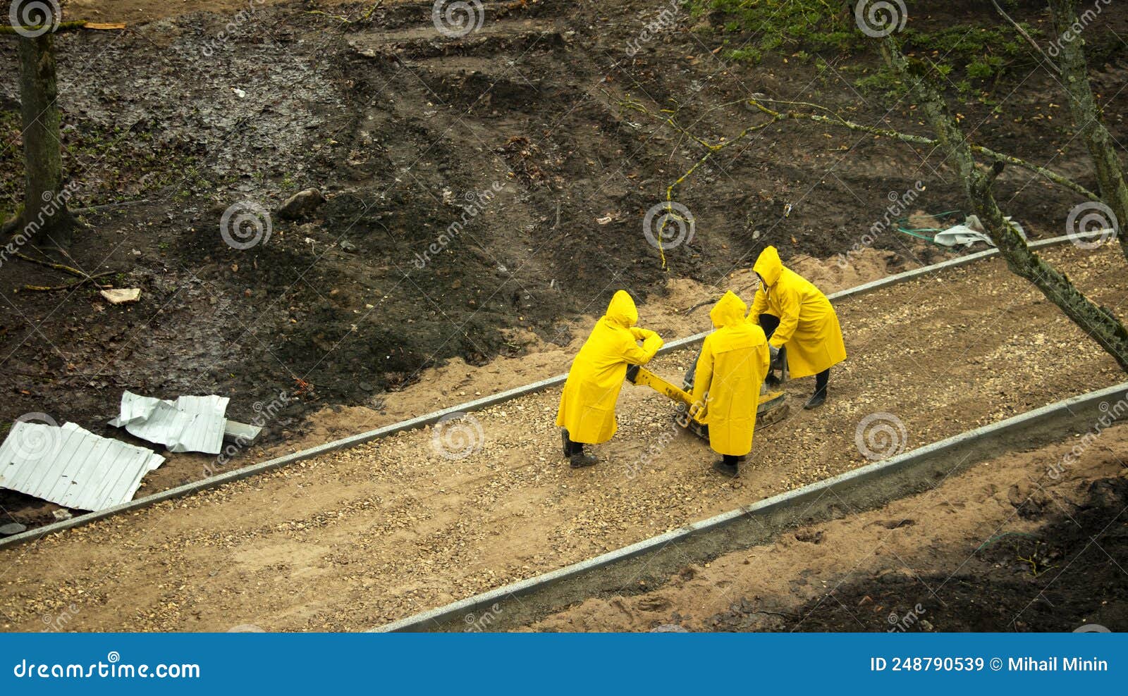 Three Workers in Yellow Raincoats at a Construction Site, Stock Image ...