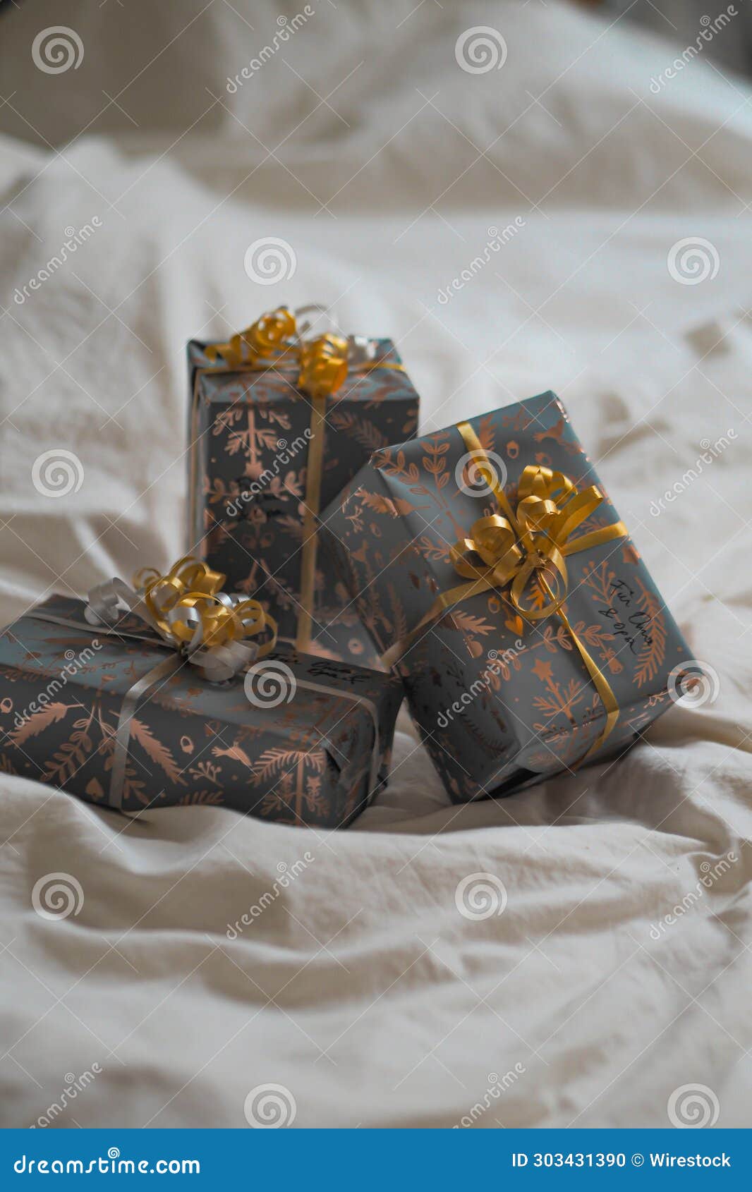 Three Wrapped Presents are on the Bed on a Sheet with a Bow Stock Photo ...