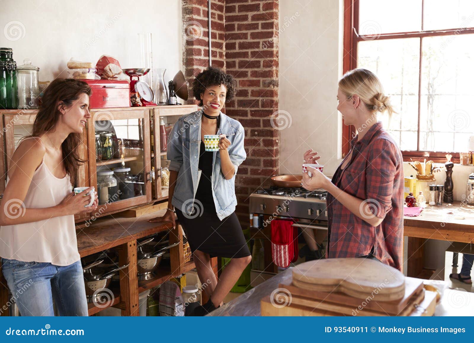 Three Young Adult Girlfriends Talk Over Coffee in Kitchen Stock Image ...